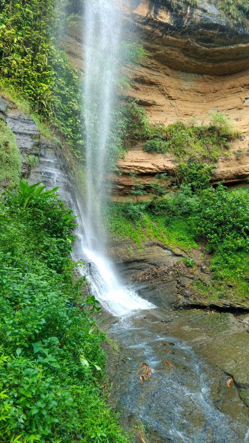 A Clear Waterfall with Water Falling Rapidly between Tall Red Rocks in ...