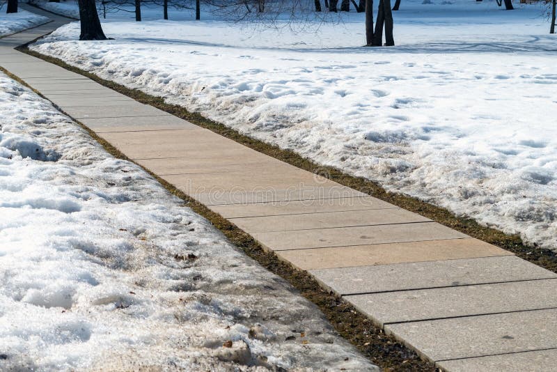 A Cleared Path Made of Granite Slabs in a Snow-covered Park Stock Photo ...