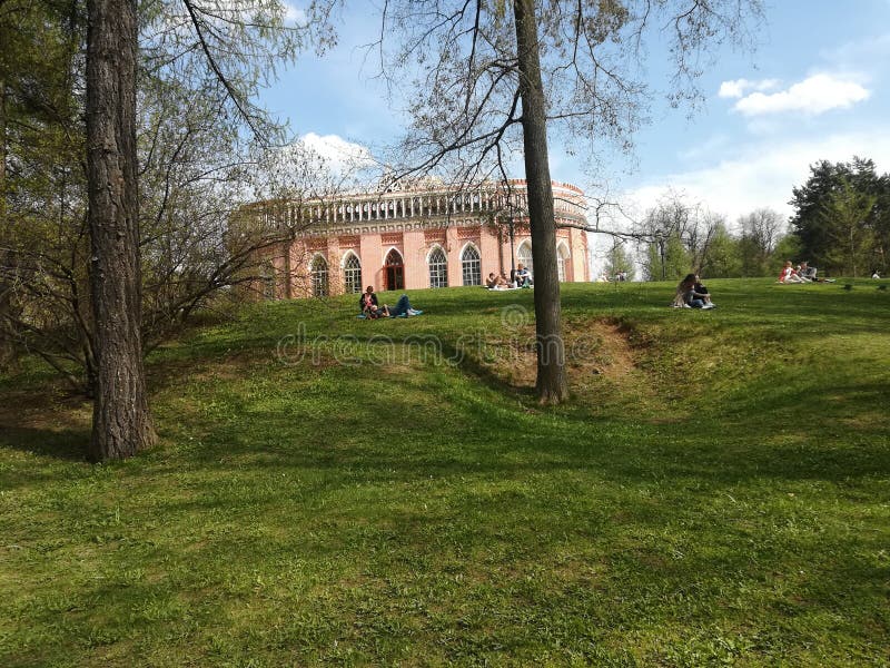 A Clearing with Bright Green Grass and Trees and a Historic Building ...