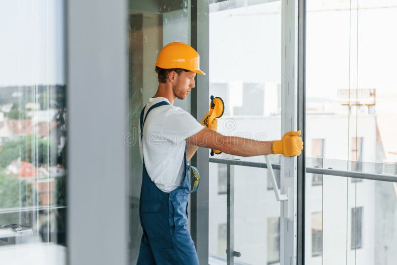 Clearing Windows. Young Man Working in Uniform at Construction at ...