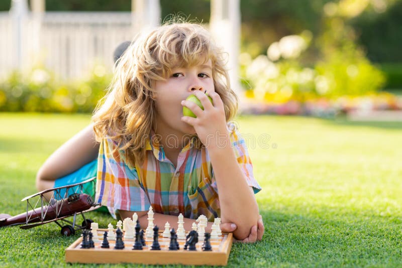 Clever Concentrated and Thinking Kid Boy Playing Chess and Eating Apple ...