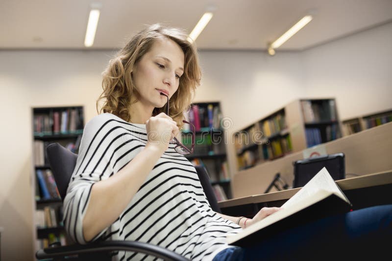 Clever Student with Open Book Reading it in College Library Stock Image ...