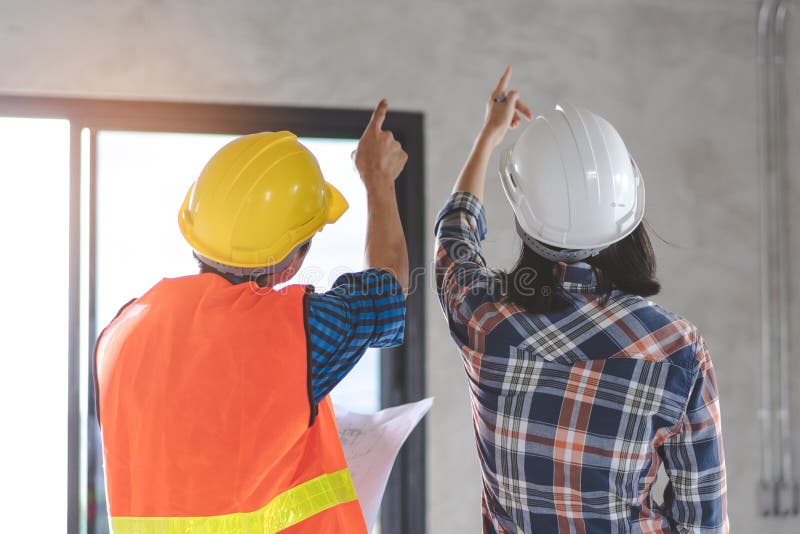 Client and Contractor Look at Blueprint and Planning To Renovation Room ...