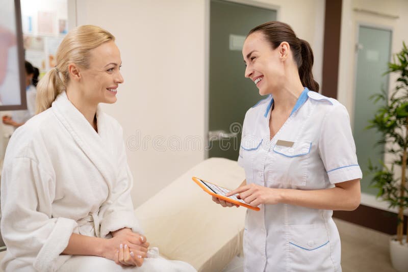 Client and Cosmetologist Smiling To Each Other after Nice Procedure ...