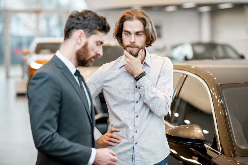 Cliente Dell'uomo Con Il Commesso Che Sceglie Automobile Nella Sala D ...