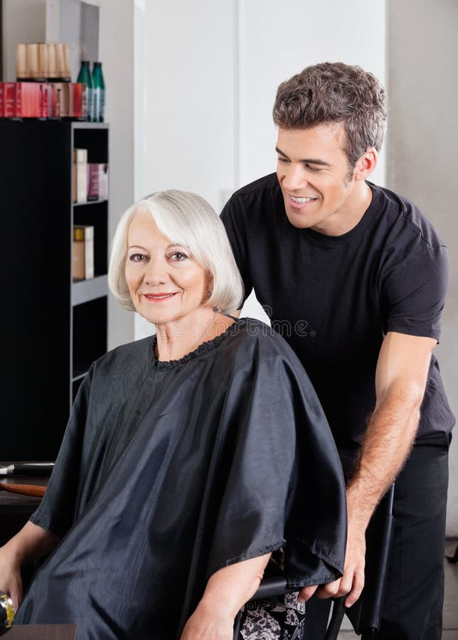 Cliente Che Fa Raddrizzare Capelli Dal Parrucchiere Fotografia Stock ...