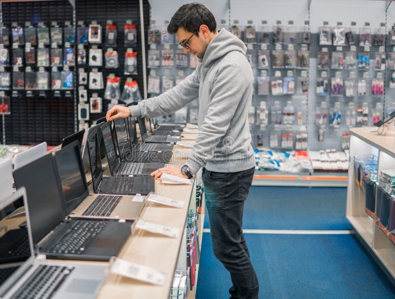 Cliente Maschio Moderno Che Sceglie Computer Portatile Nel Negozio Di ...