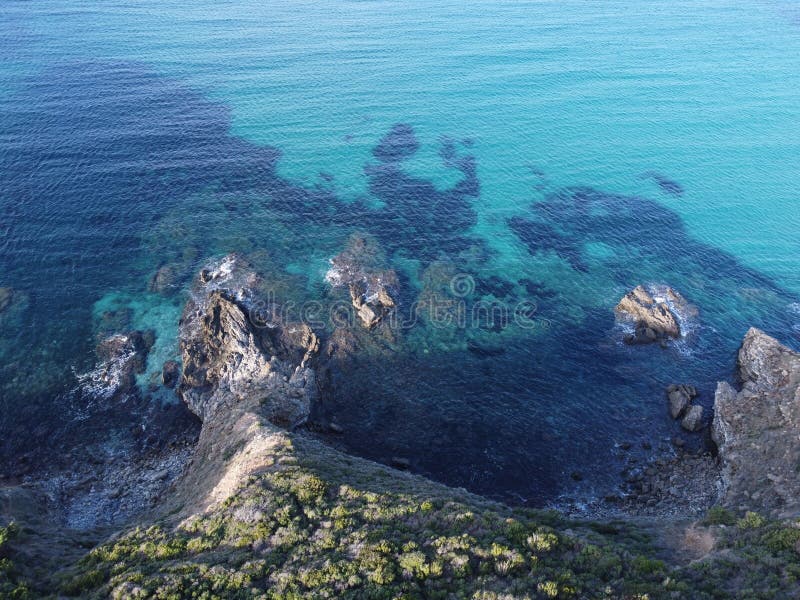 Cliff Side of Ostriconi Beach with Dark Outlines in Water Stock Image ...