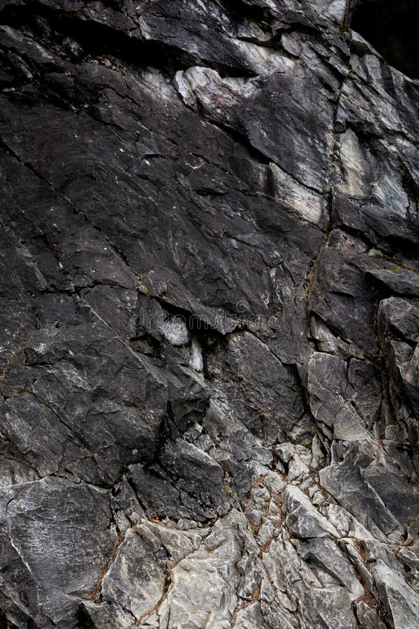A Cliff Wall of Marble Rock with Cracks and Chips, Black and Gray ...