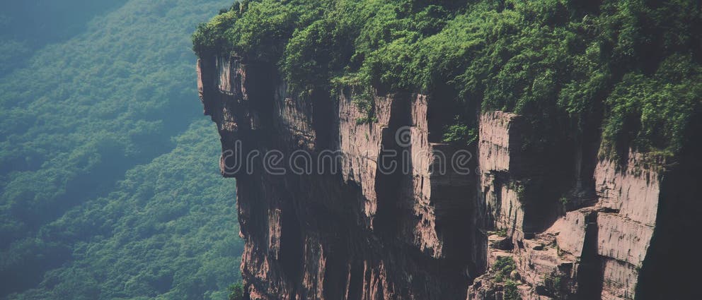Cliffs Rise Dramatically with Layered Rock Formations and Lush Greenery ...