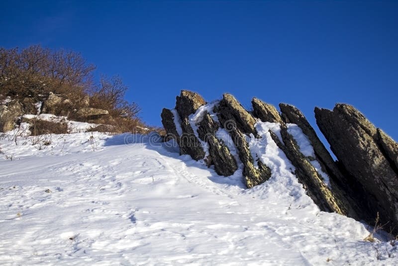 Cliffs on a snowy peak stock photo. Image of mountain - 215061396