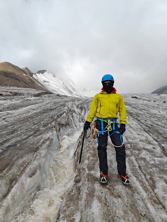 A Climber Stands on a Glacier, Equipped for a Challenging Ascent in ...