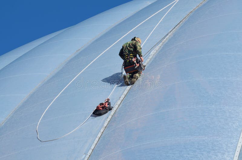 The Climber is Working on the Roof. Editorial Photo - Image of gear ...