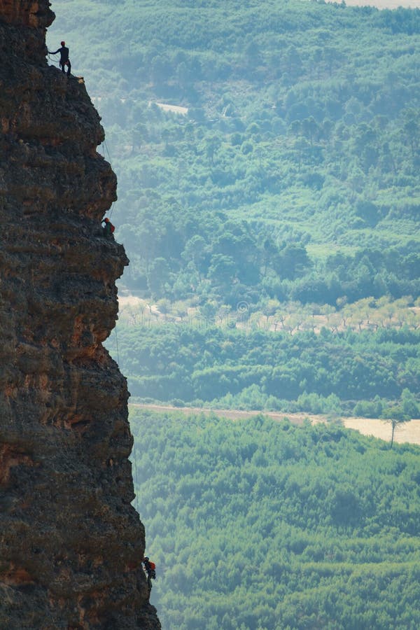 Climbers Hanging by a Cliff Edge Against Land, Vertical Composition ...