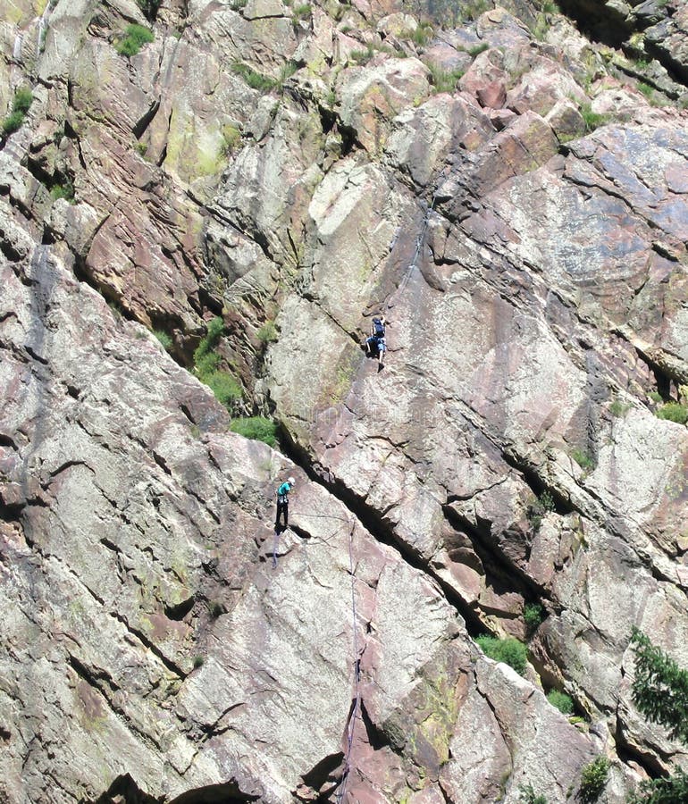 Climbing a sheer rock face stock image. Image of front - 407941
