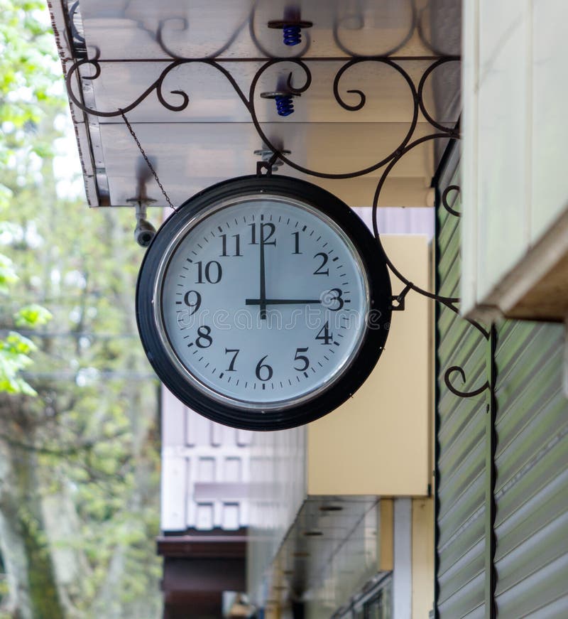 A Clock Hanging on a Building with the Hands at 3:00 Stock Photo ...
