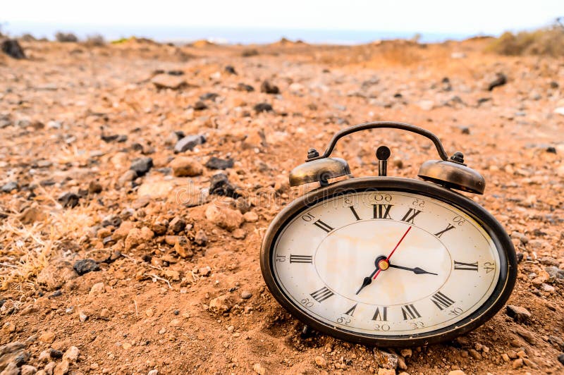 A Clock is Laying on the Ground in a Desert Stock Photo - Image of ...