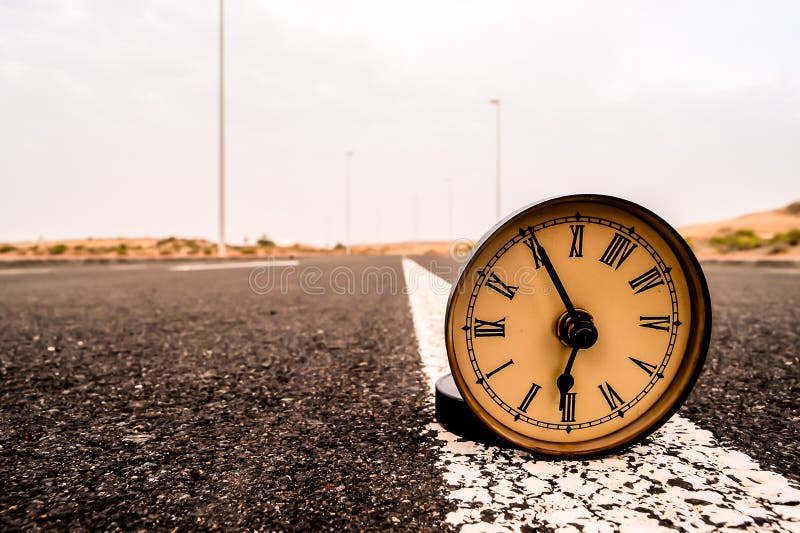 A Clock is Laying on the Road, with the Hands Pointing To the Numbers 1 ...