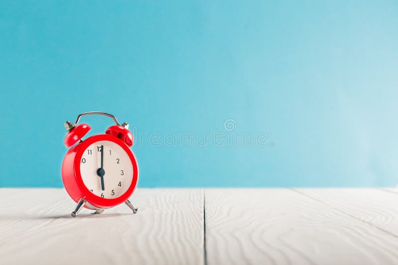 Clock on Light Wooden Table with Colorful Background. Time for Wake Up ... Clock on Light Wooden Table with Colorful Background. Time for Wake Up ...