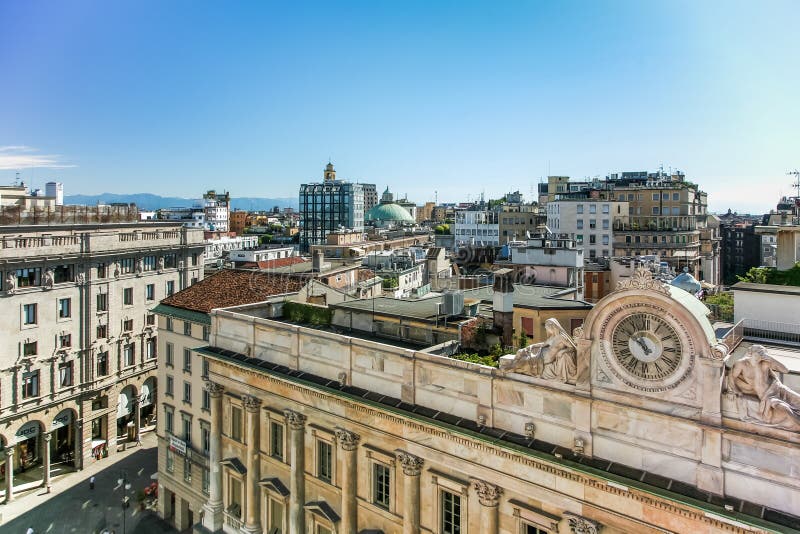 A Clock Tower with a Clock on it is in the Middle of a Milano City ...