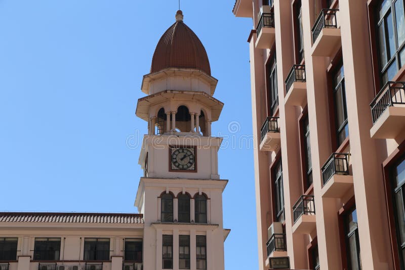 A Photo of the Clock Tower in Front of Two Buildings, with a Clear Blue ...