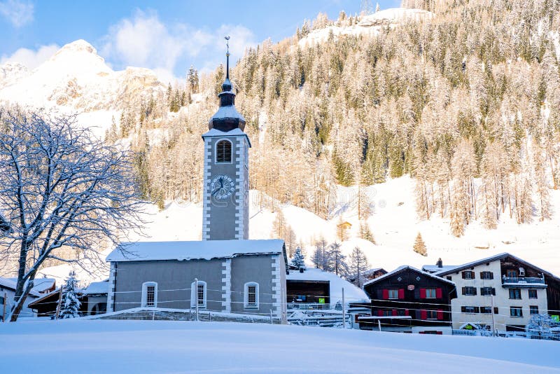 Clock Tower in a Rural Area with Houses Covered in Snow during Winter ...