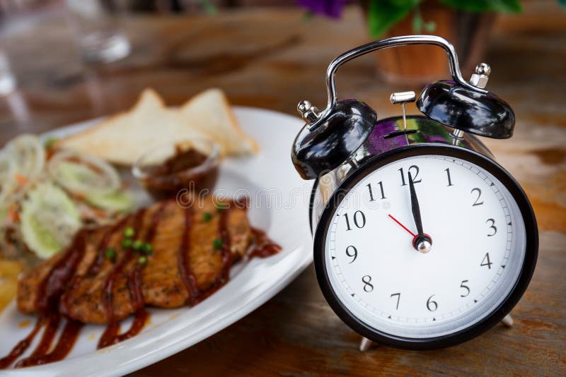 Clock on Wooden Table with Steak on Background Stock Image - Image of ...