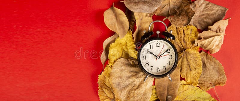 Clock on Yellow Autumn Leaves with Red Banner Background Stock Image ...