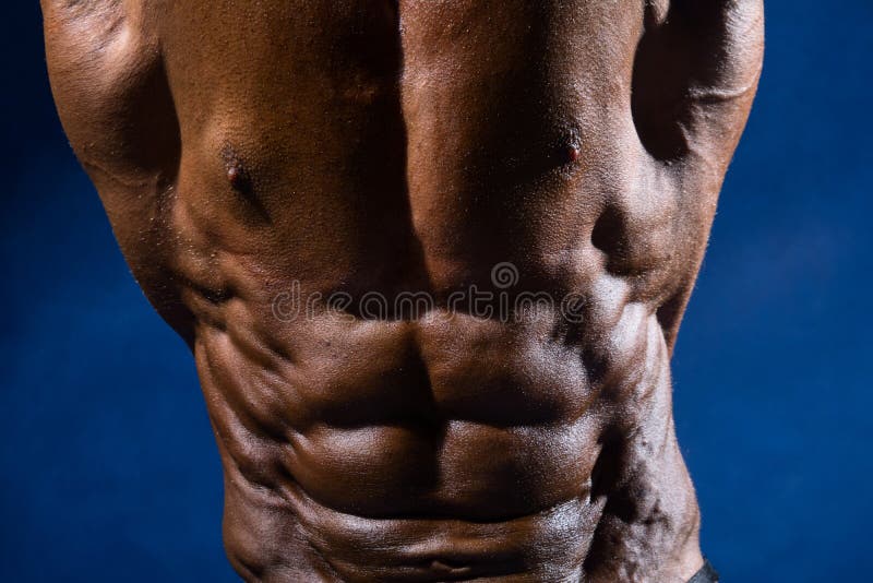 Close-up of Abdominal Muscles Bodybuilder on a Blue Background Stock ...