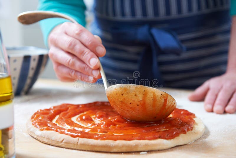 Close Up of Adding Tomato Sauce To Pizza Base Stock Photo - Image of ...