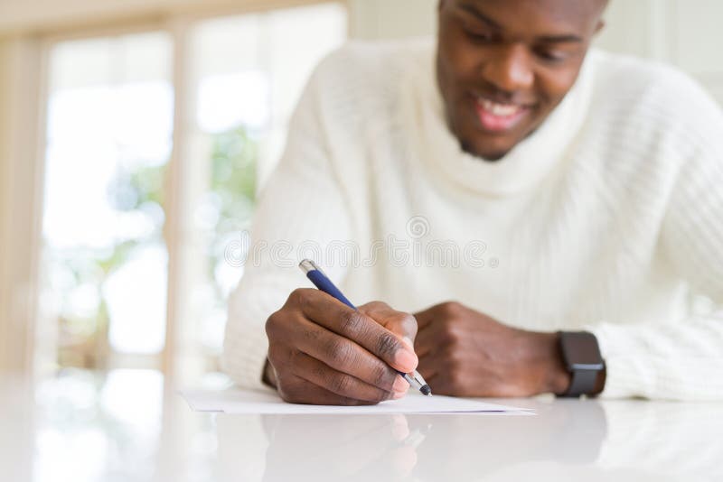 Close Up of African Man Writing a Note on a Paper Smiling Confident ...