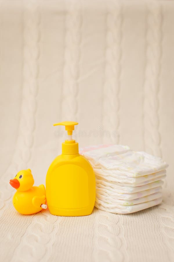 Close Up Baby Hygiene Items. Stack of Diapers, Liquid Soap and Yellow ...