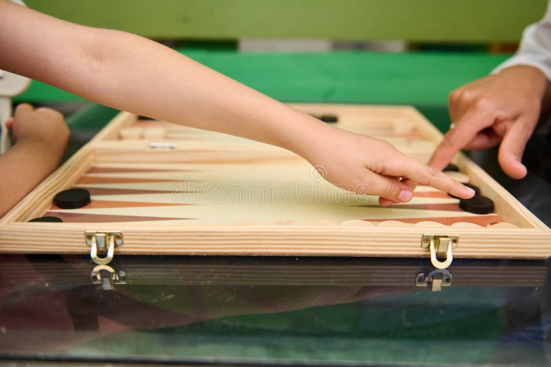 Close-up of Two Hands Playing Backgammon, with One Hand Pointing and ...