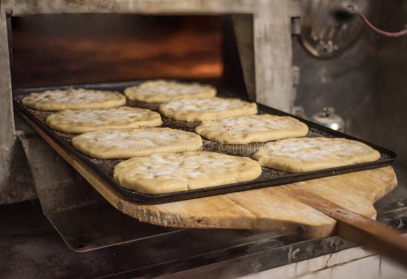 Baker Putting a Rack of Pastries into the Oven in Bakery or Pastry Shop ...