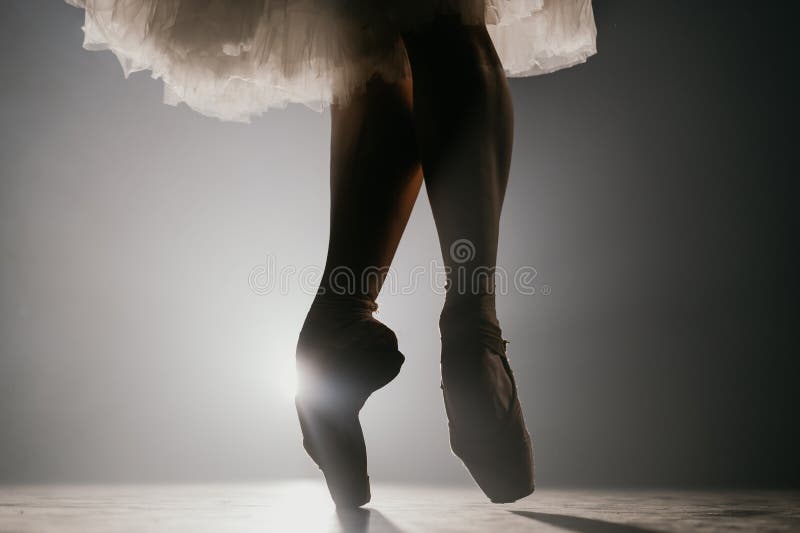 Close Up Of Ballet Dancer As She Practices Exercises On Dark Stage Or