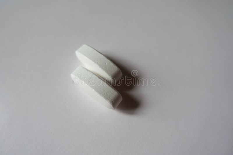 Closeup of 2 Big White Oblong Caplets of Calcium Citrate Stock Image ...