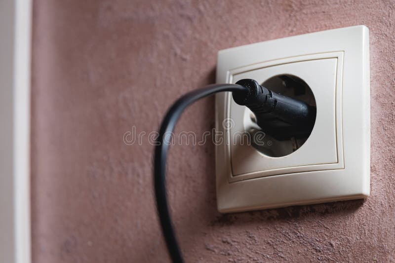 Close-up of a Black Electric Plug in a 220 Socket in the Wall. Power on ...