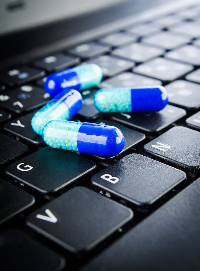 Close Up of Blue Pill on Laptop Keyboard Stock Image - Image of close ...