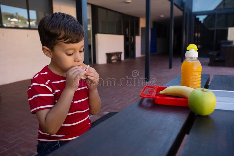 Close Up of Boy Eating while Sitting by Table Stock Photo - Image of ...