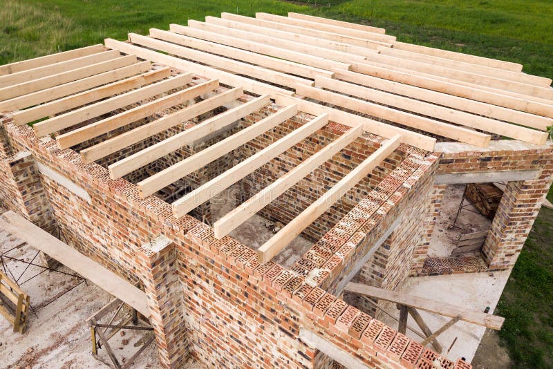 Close Up of a Brick House with Wooden Ceiling Frame Under Construction ...