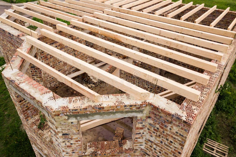 Close Up of a Brick House with Wooden Ceiling Frame Under Construction ...