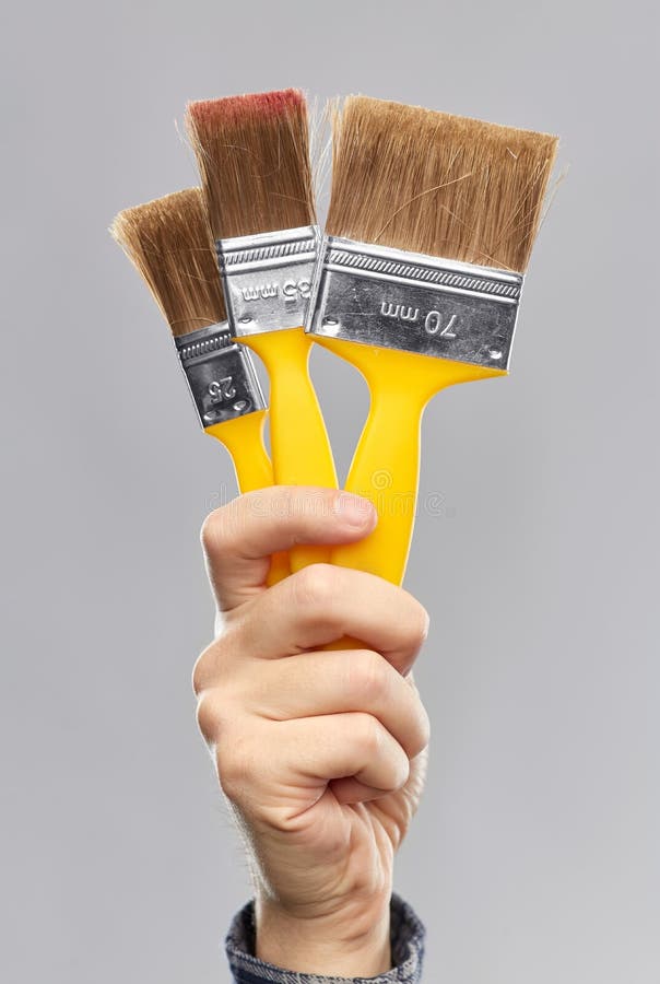 Close Up of Builder`s Hand Holding Paint Brushes Stock Photo - Image of ...