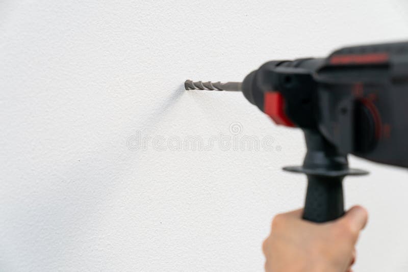 Close Up Builder or Worker Hand Drilling with a Machine on White Wall ...