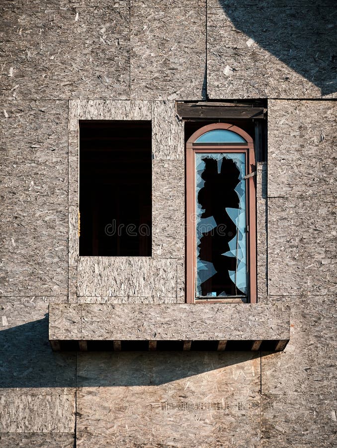 A Close-up of a Building Under Construction, Featuring a Broken Window ...