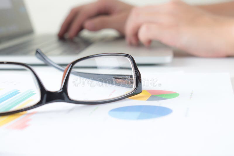 Close Up of Business Glasses on the Desk with Charts and Laptops at ...