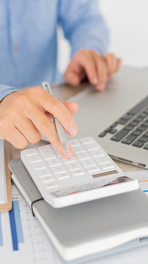 Close-up Business People Using a Calculator To Write Notes with ...