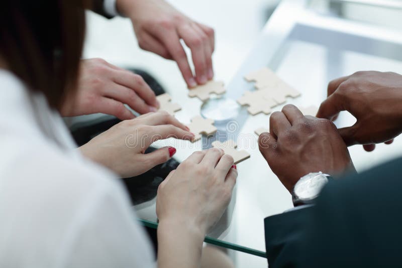 Close Up. Business Team Assembling Puzzle Pieces. Stock Photo - Image ...