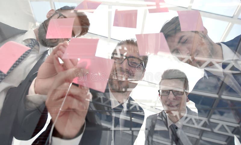 Close Up.business Team Reading Sticky Notes on Glass Stock Photo ...