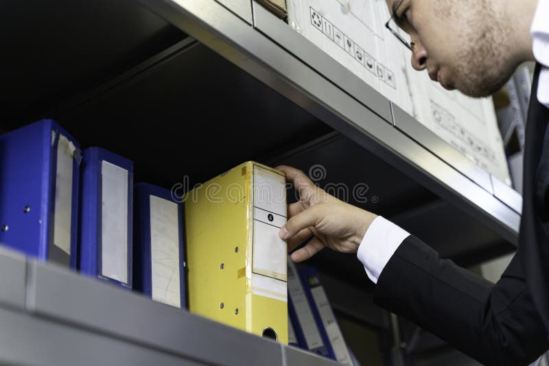 Close Up of Businessman S Hand Picking Up Yellow Folder from Shelf in ...