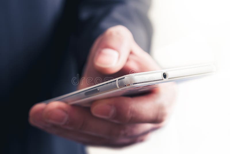 Close Up of a Businessman Touching a Mobile Phone in Front of a Bright ...